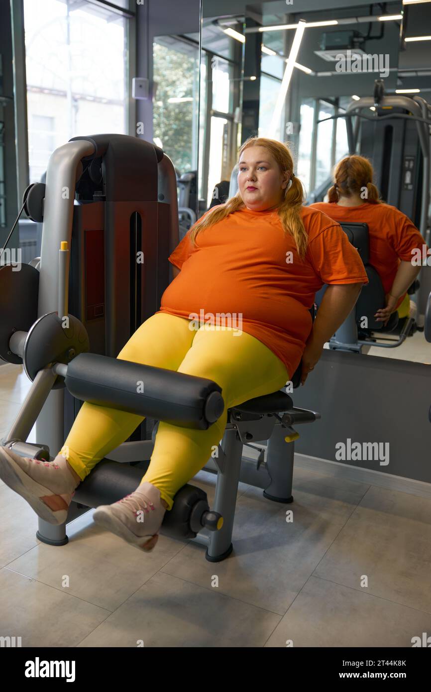 Beautiful chubby girl training at gym doing legs pump exercises Stock ...