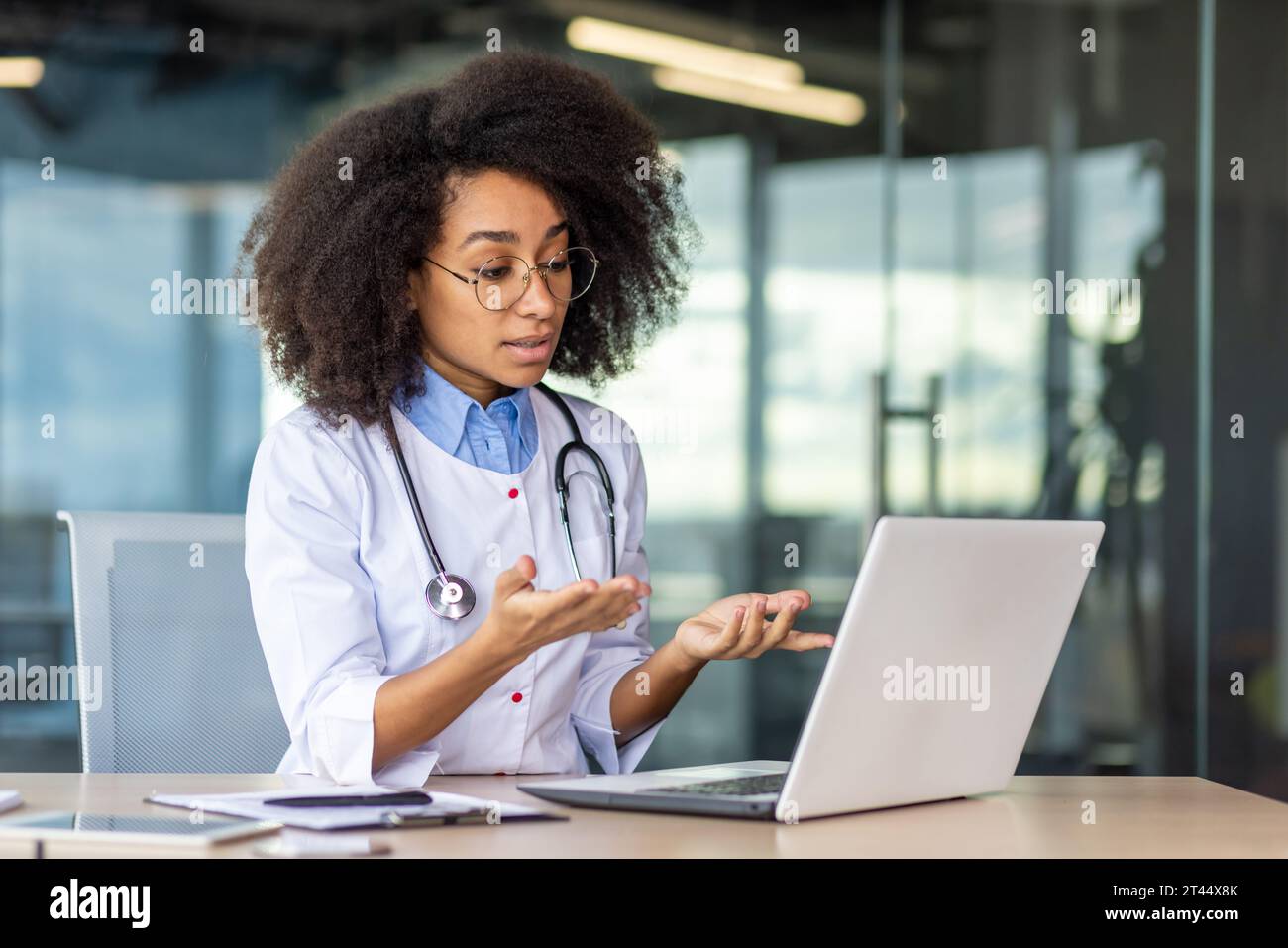Young beautiful female doctor using laptop for video call, serious and ...
