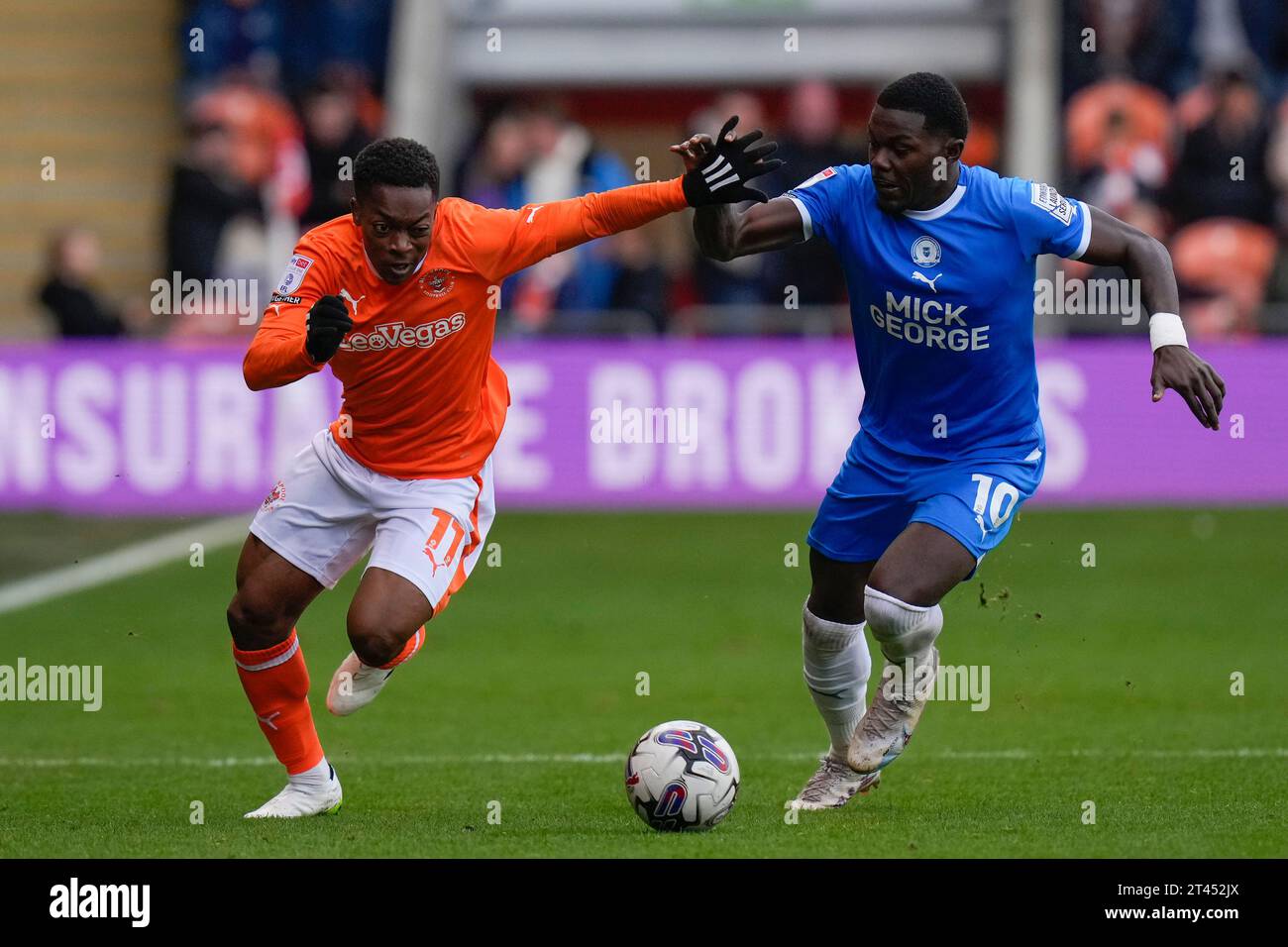 Karamoko Demb l #11 of Blackpool holds off Ephron Mason-Clark #10 of ...