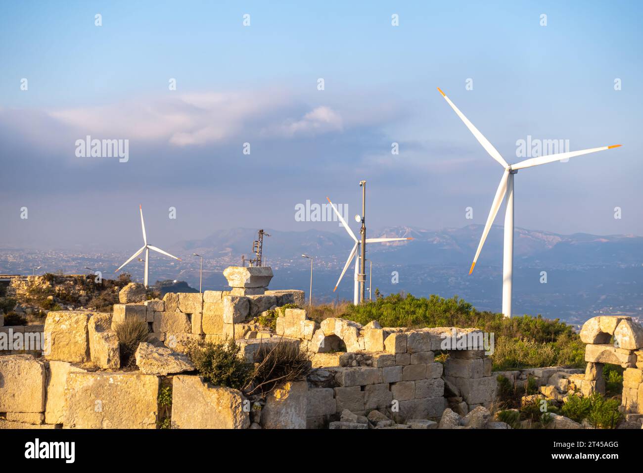 Wind turbines in Hatay Turkey behind the ruins of historic Monastery of ...