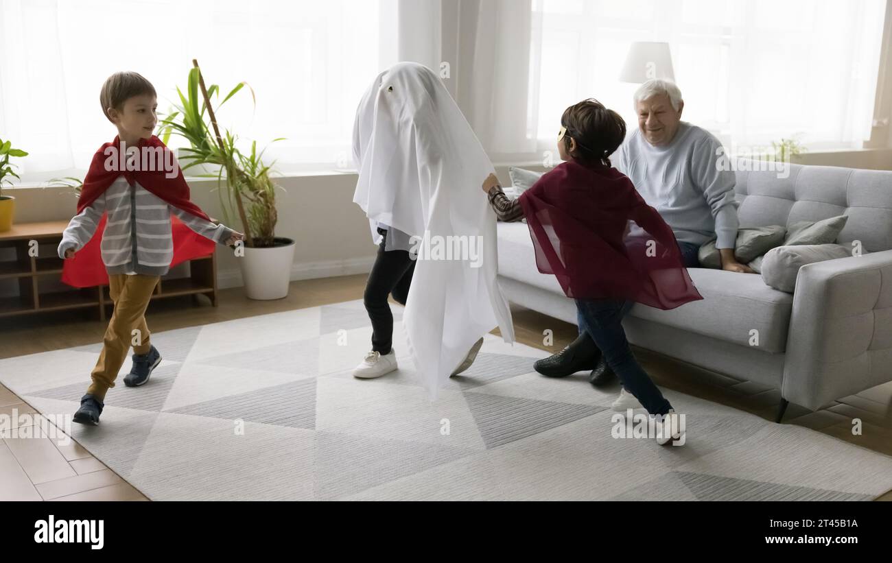 Older great-grandpa spend time with three great-grandsons at home Stock ...