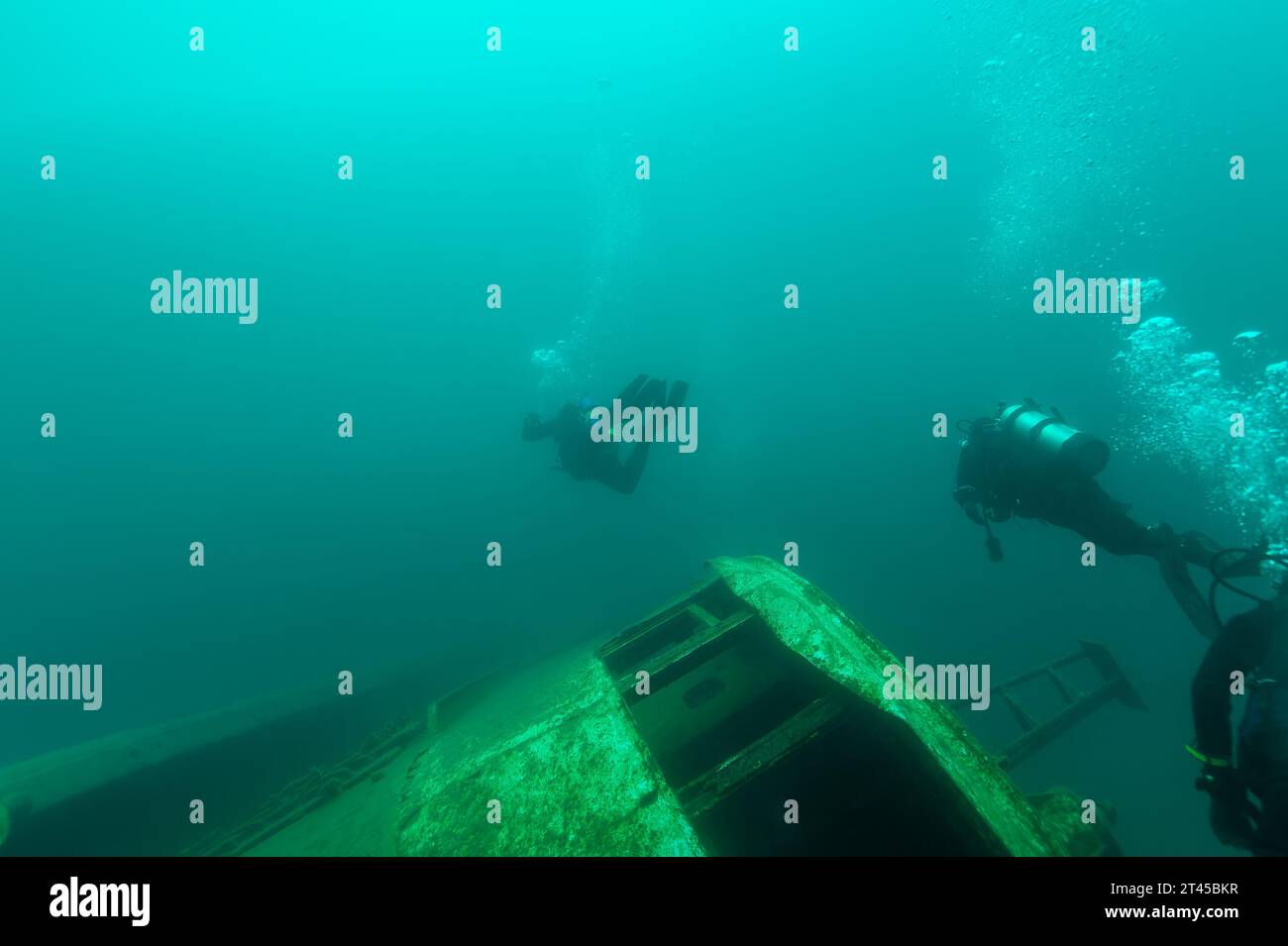 Multiple SCUBA divers exploring tugboat Stephen Selvic shipwreck Stock ...