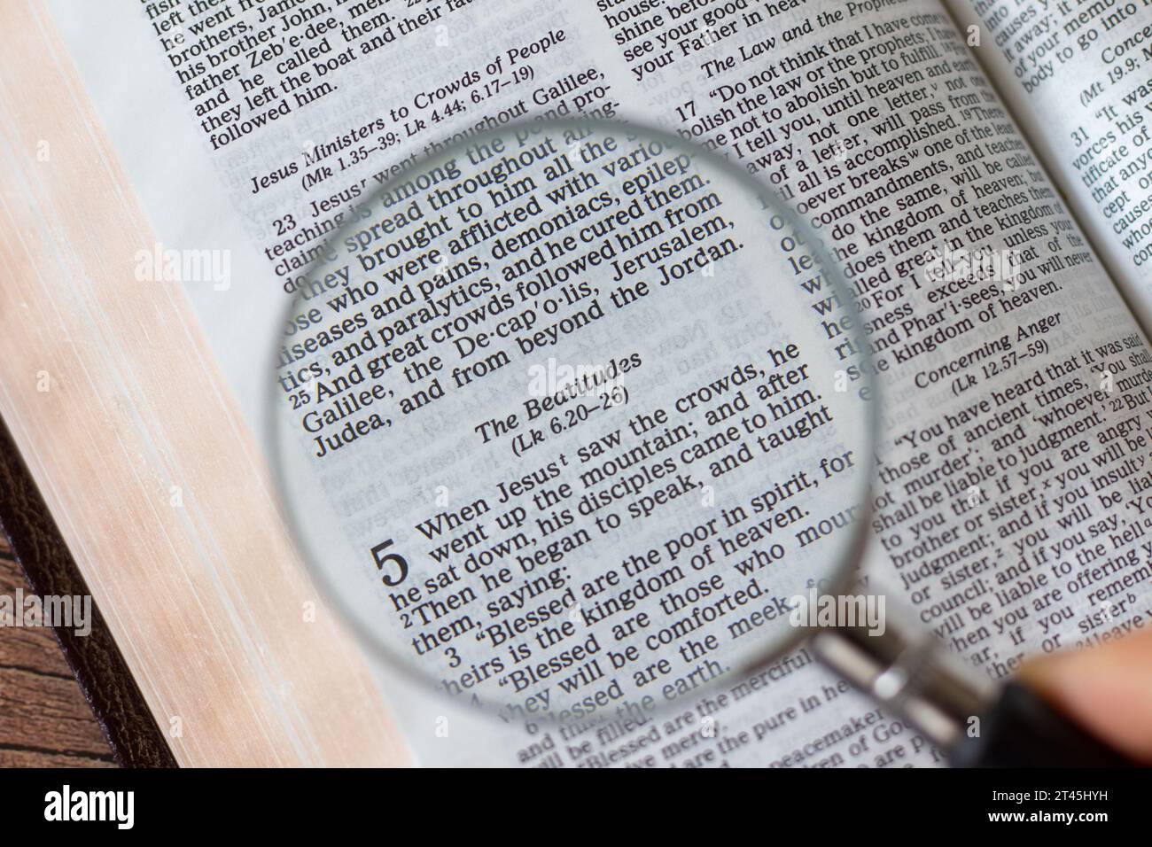 "Beatitudes", verses in an open Holy Bible Book with a magnifying glass ...