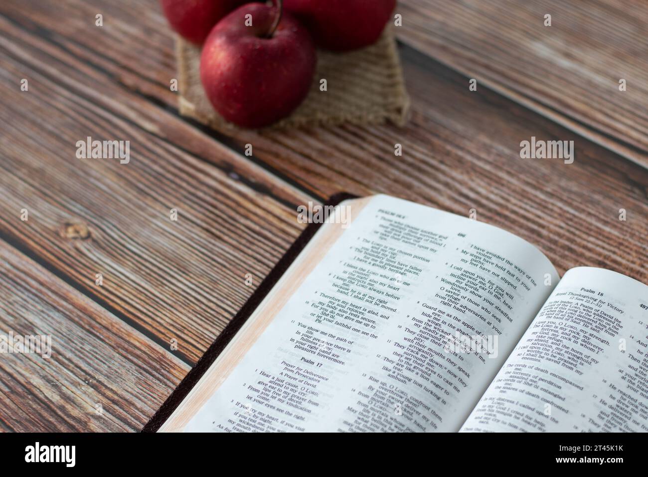 Red apples and open Holy Bible Book on a wooden table. Copy space ...