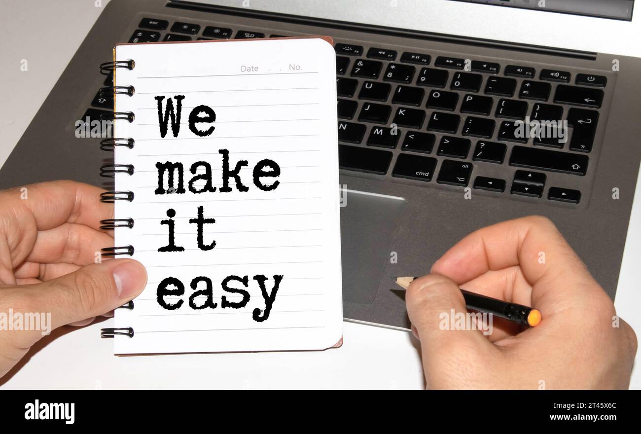 WE MAKE IT EASY text on a notebook on green paper Stock Photo - Alamy