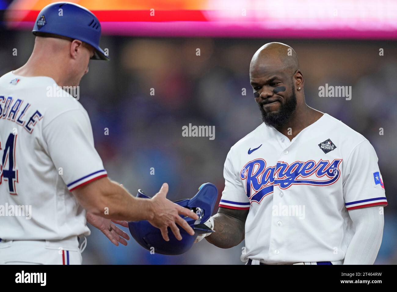 Texas Rangers' Adolis Garcia, right, hands his helmet to first base ...