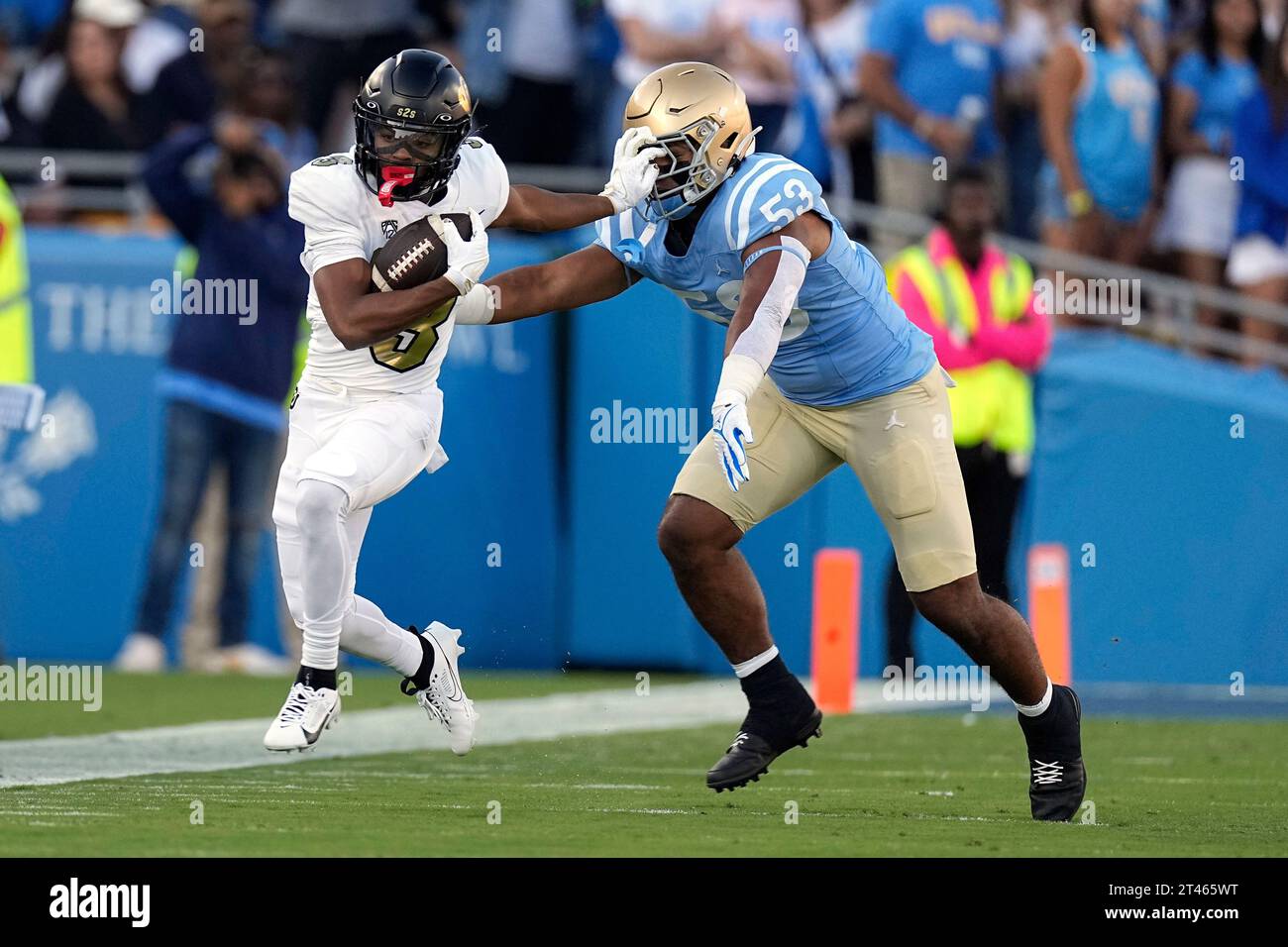 Colorado running back Dylan Edwards, left, fends off UCLA linebacker ...