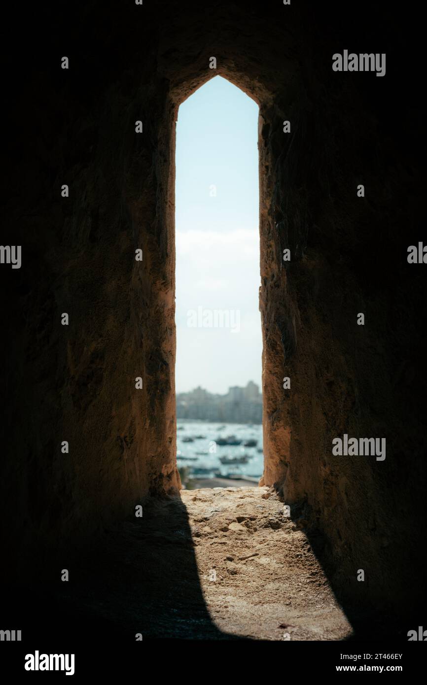 An arched window within Qaitbay Citadel in Alexandria offers a serene ...