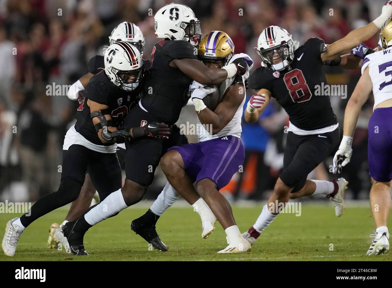 Washington running back Dillon Johnson, middle, is tackled by Stanford ...