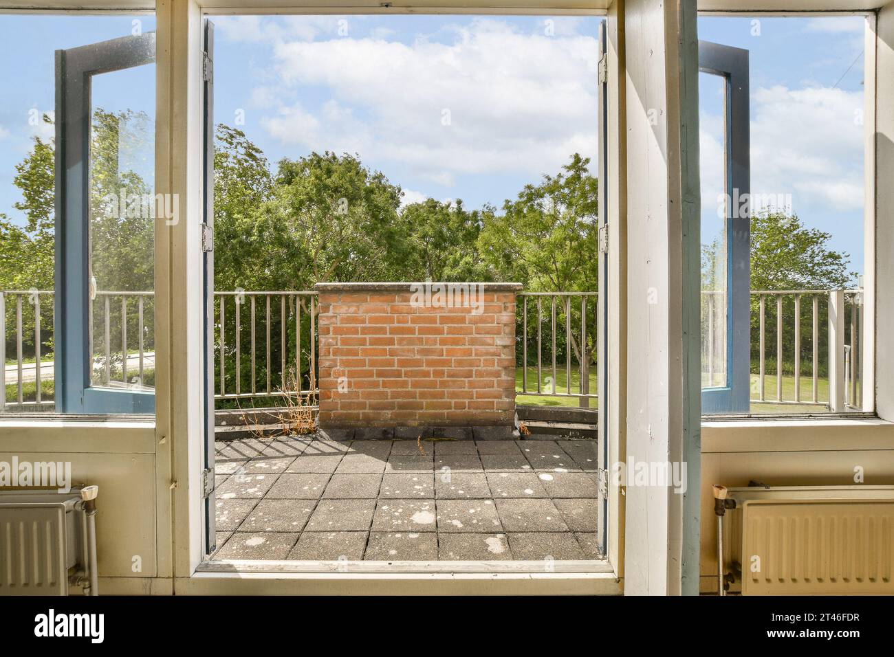 an open window with a brick wall in the middle and blue sky above it ...