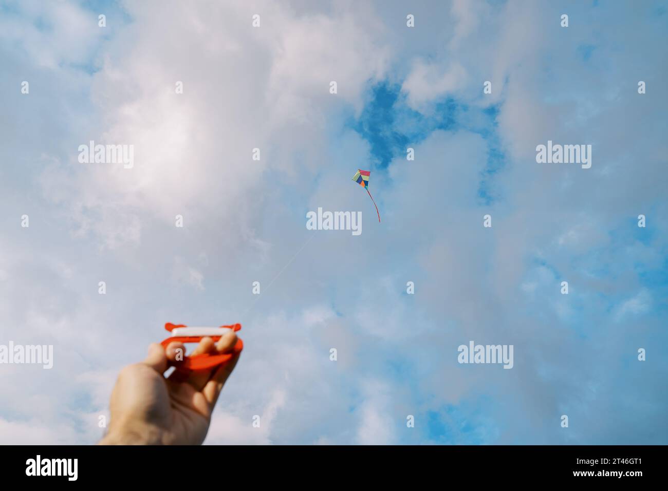 Spool of thread with a kite flying in a cloudy sky in a man hand Stock ...