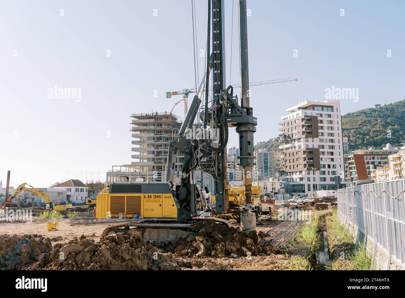 Crawler drilling machine drills the ground to install piles near a ...