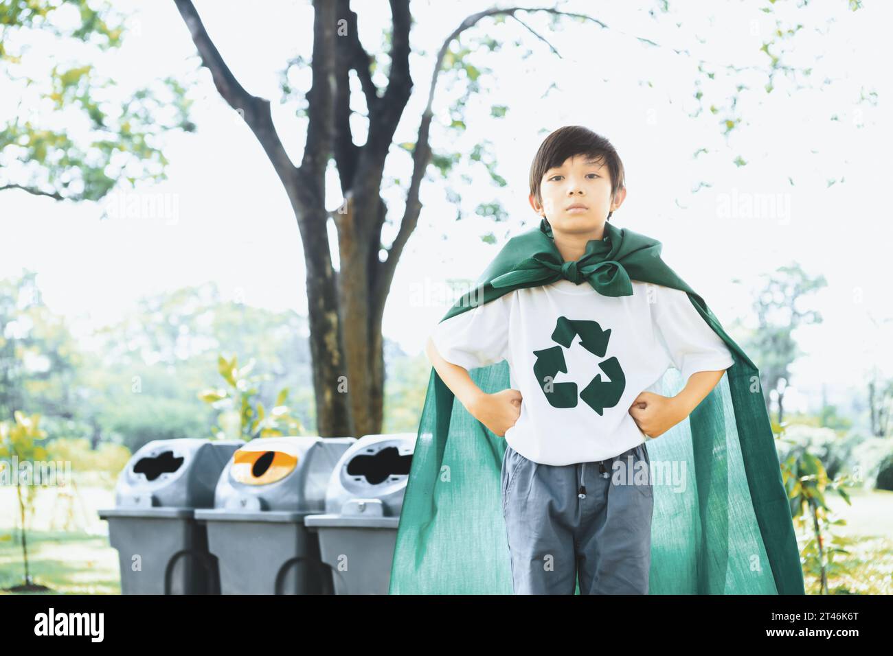 Cheerful young superhero boy with cape and recycle symbol promoting ...