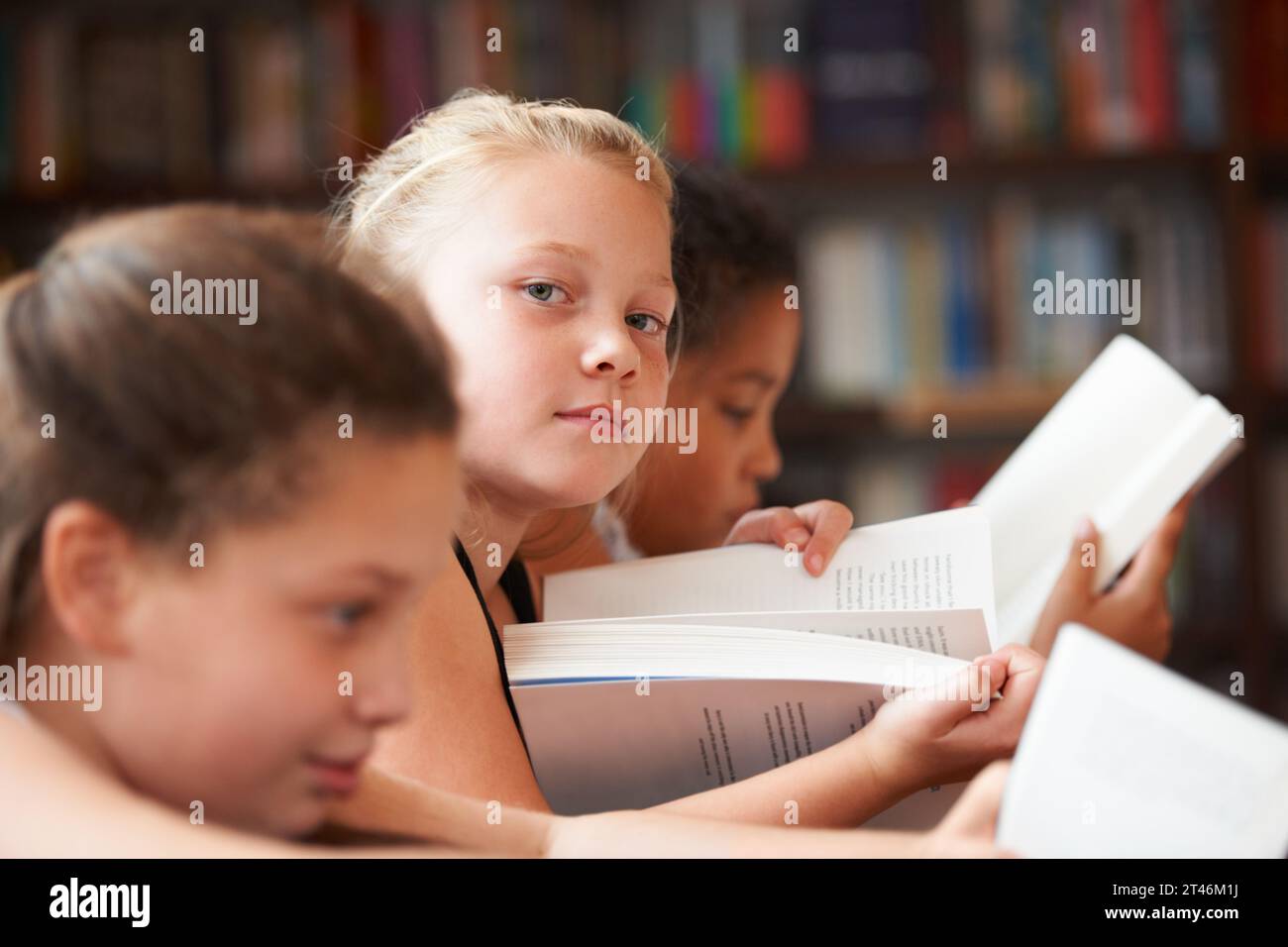 Girl, portrait and reading books in classroom for education, learning ...