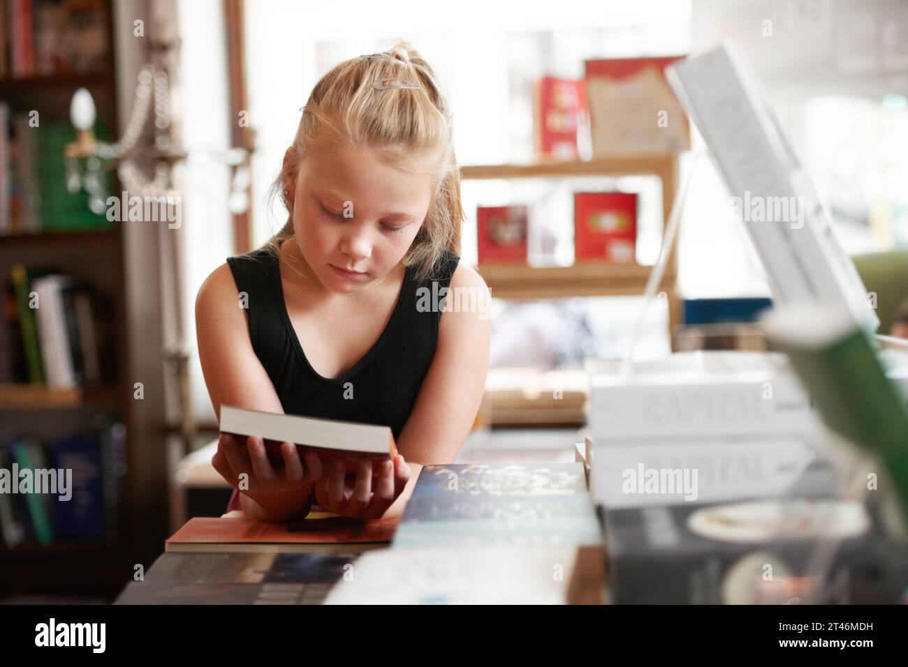 Library, reading and child student with a book in the classroom for ...