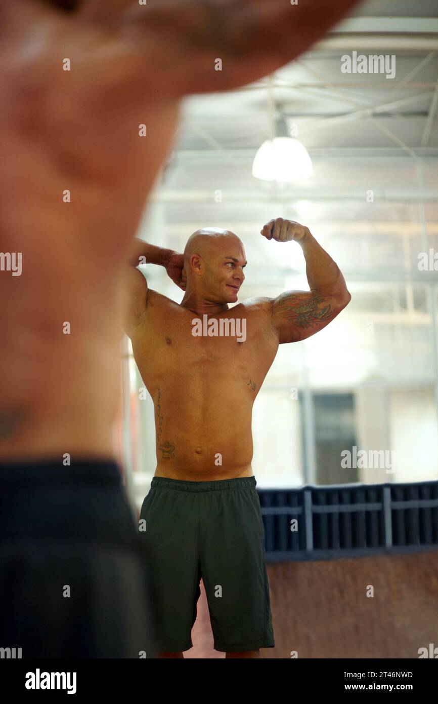 Strong man, arm flexing and mirror at gym with fitness, workout and ...