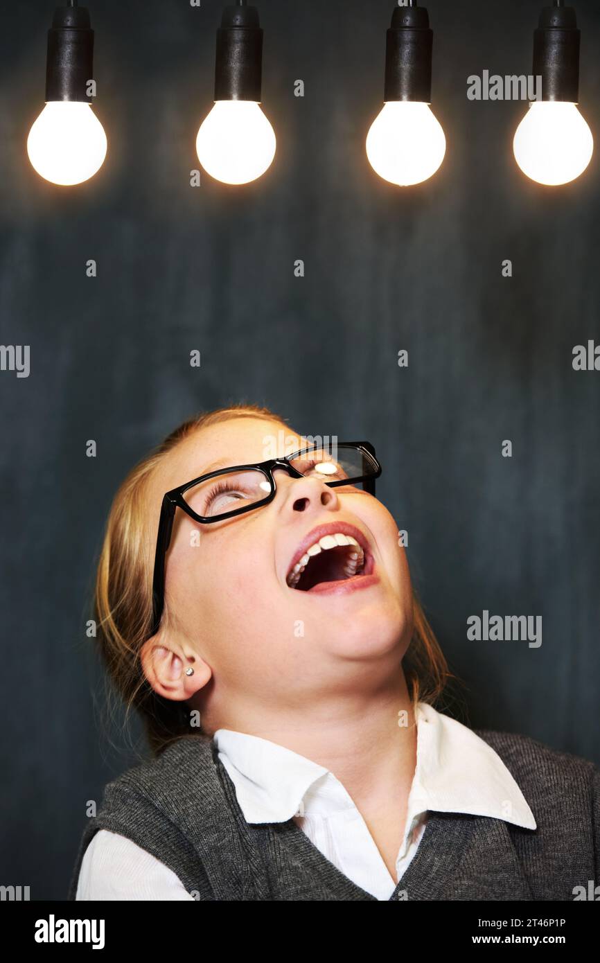 Light bulbs, smile and child student with glasses for thinking, idea or ...