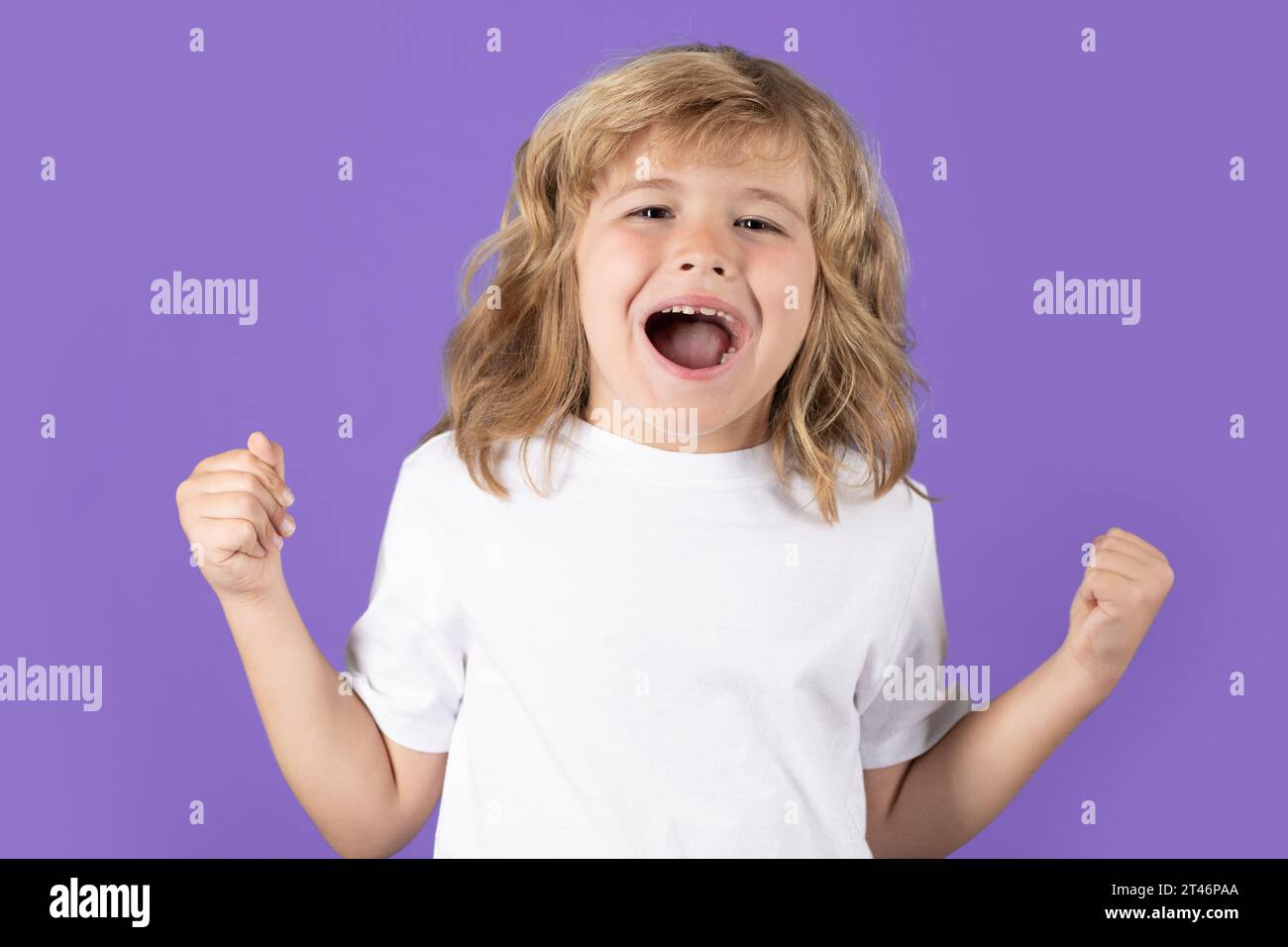 Excited kid boy celebrating victory on studio isolated background ...
