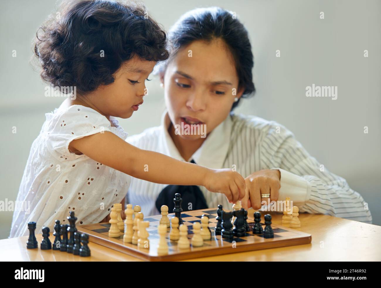 Mother, girl and chess board play for learning growth, development ...