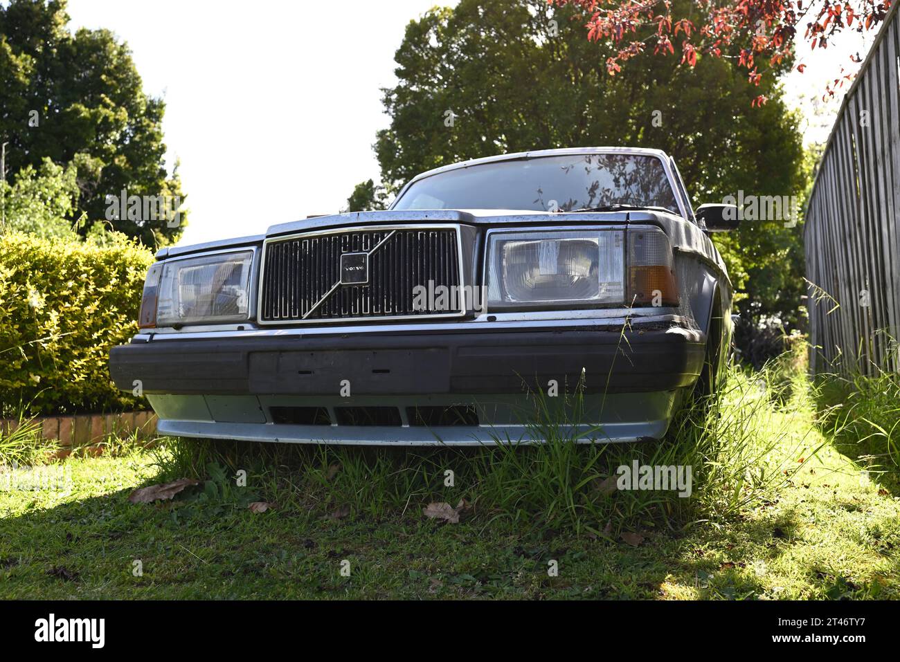 Front view of an old and abandoned Volvo 700 series parked on grass, by ...