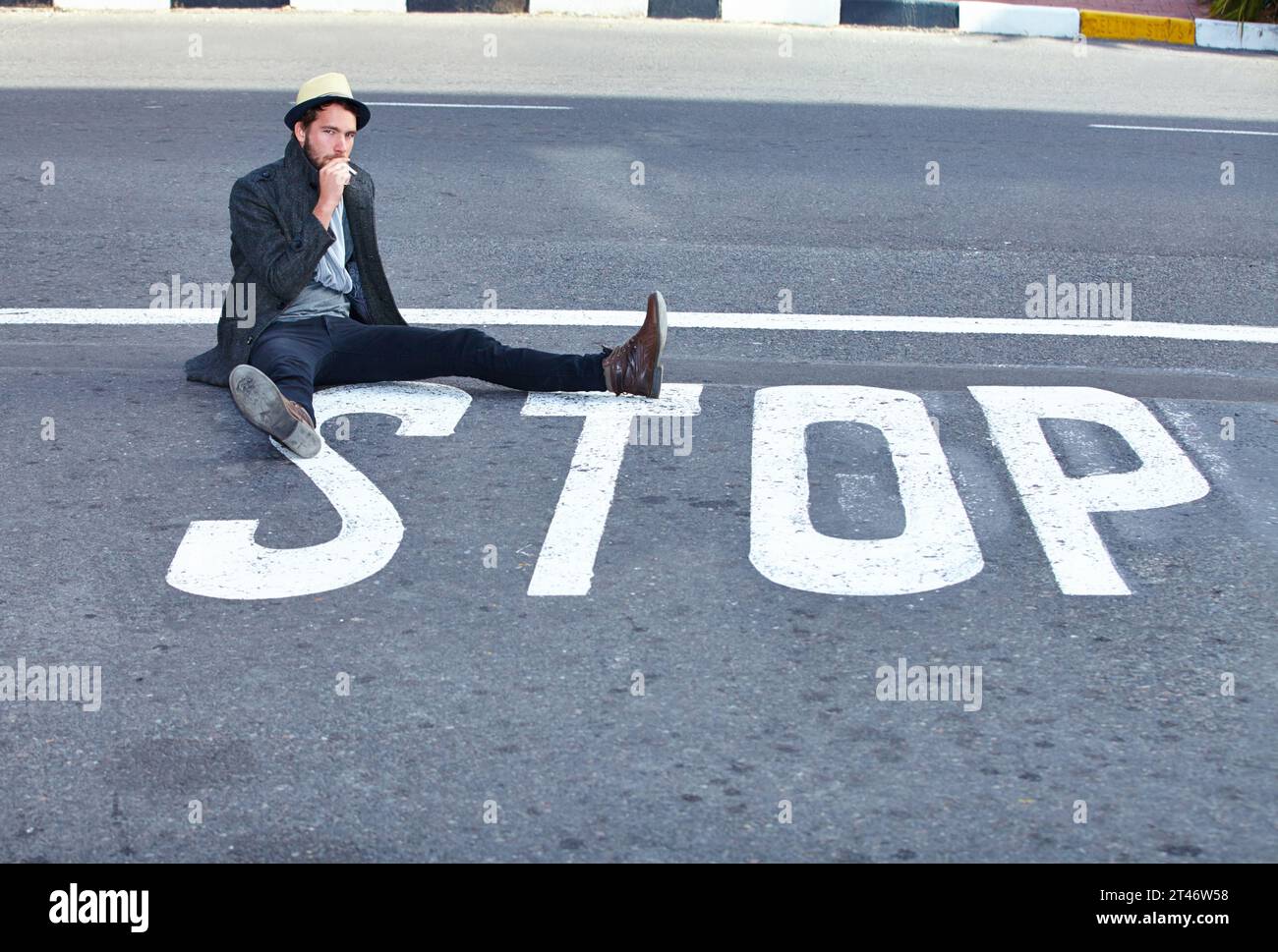 Man, asphalt and stop or sign on road, danger and sitting by symbol ...