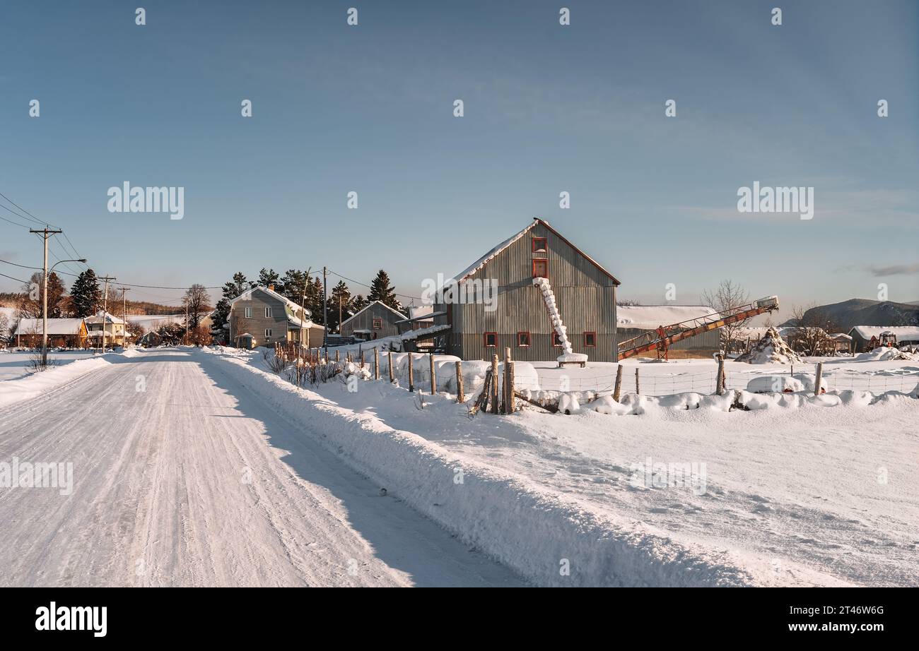 A serene snow-covered landscape with rustic houses in St-Anaclet-de ...