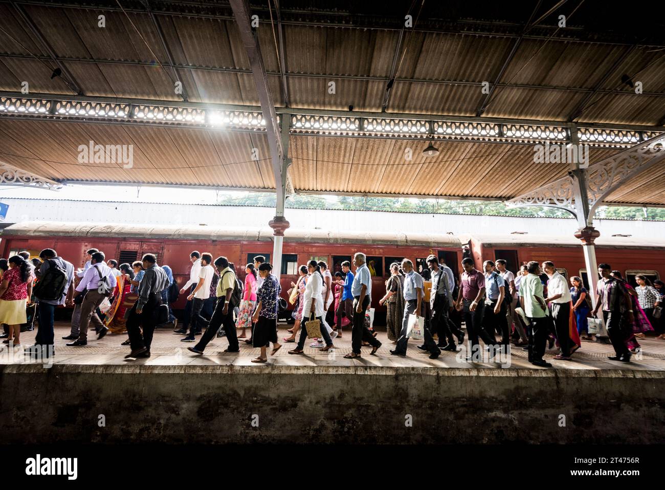 Commuters walk along the busy platform to work in the morning in Galle ...