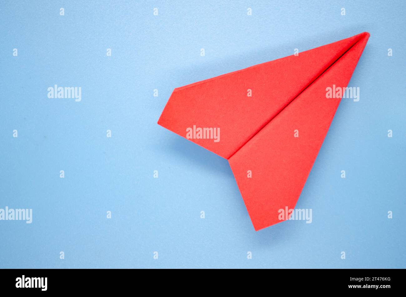 Top view of red paper airplane on blue background with customizable ...