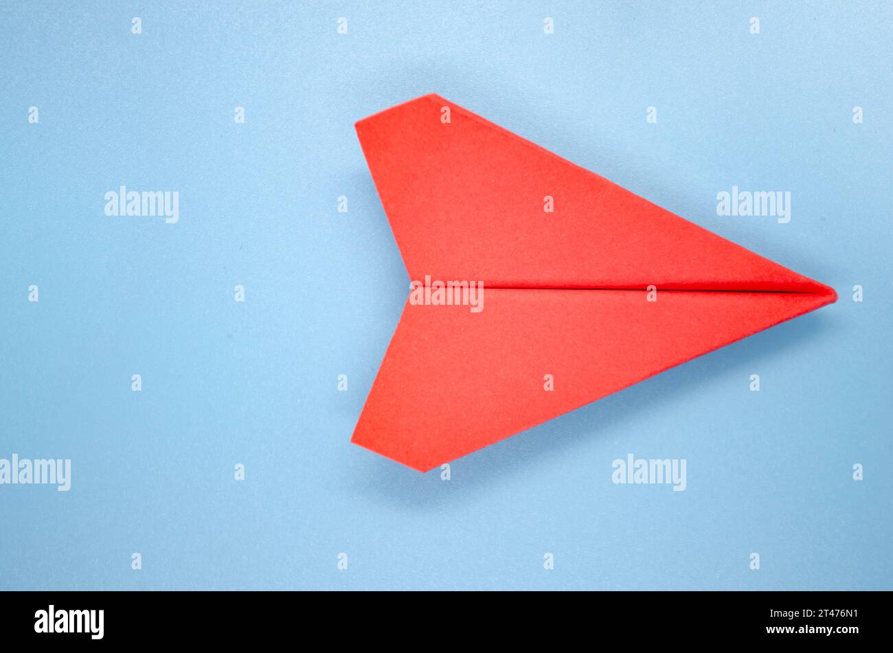 Top view of red paper airplane on blue background with customizable ...