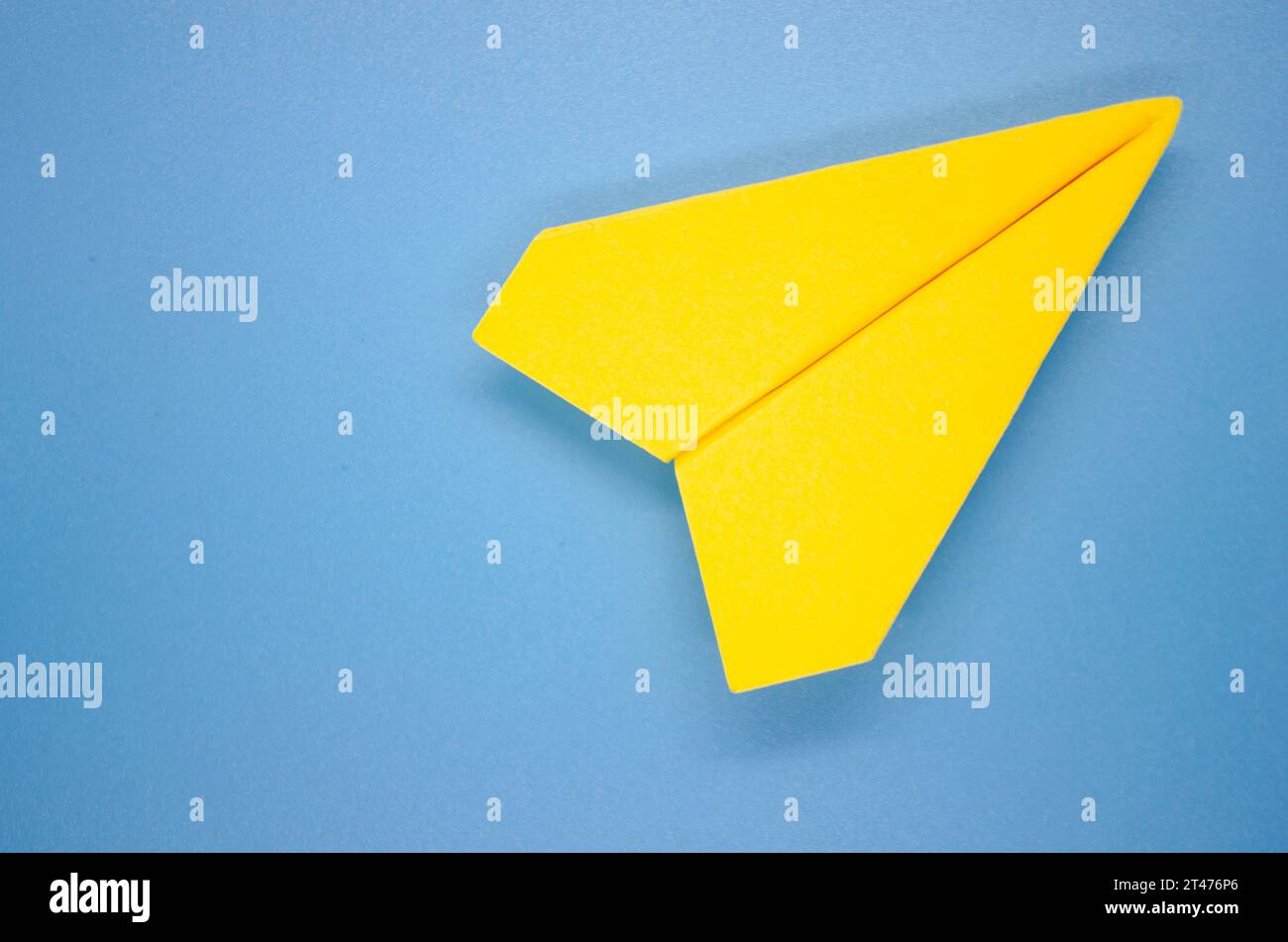 Top view of yellow paper airplane on blue background with customizable ...