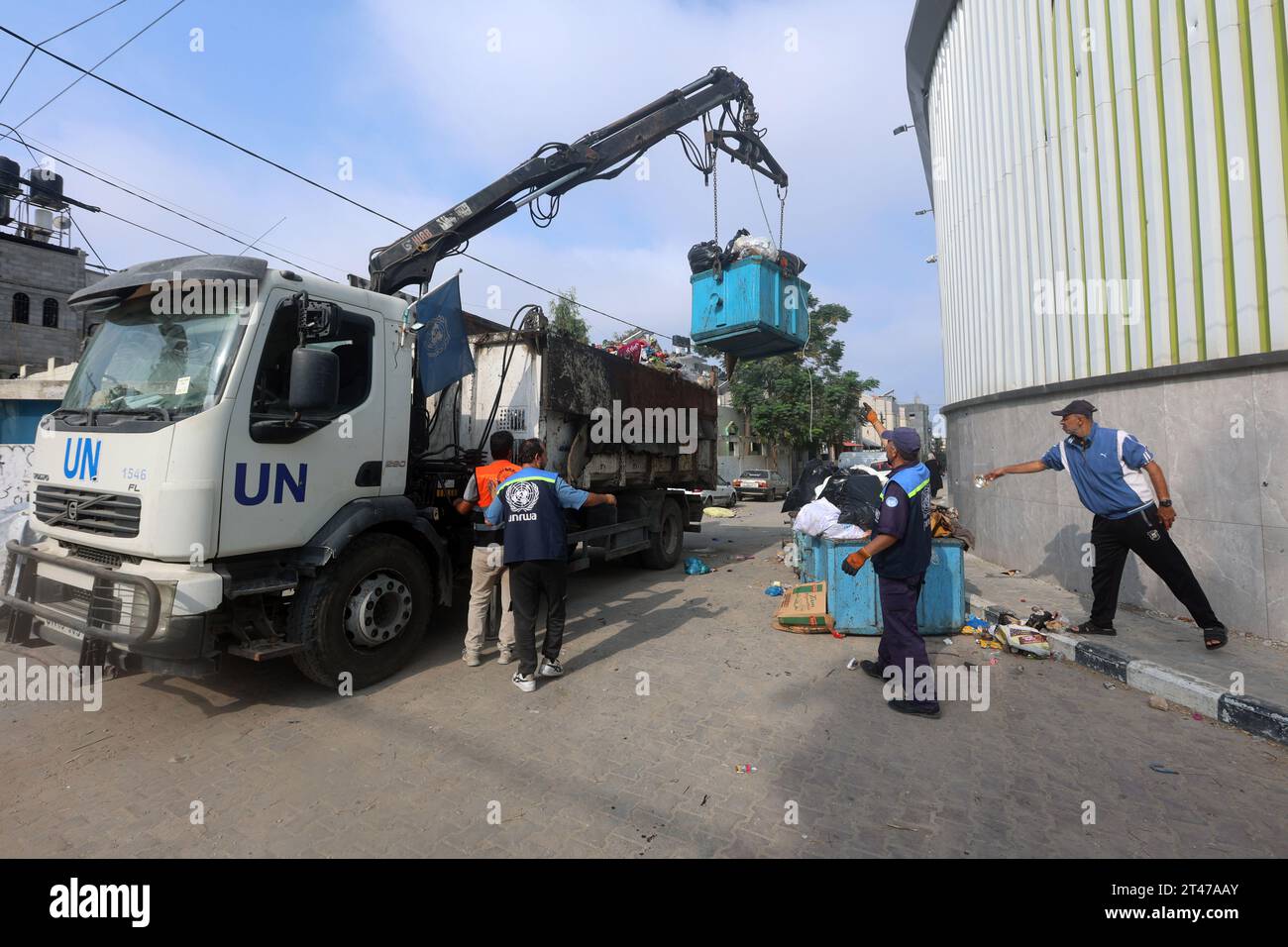 United Nations workers clean waste produced by displaced persons ...