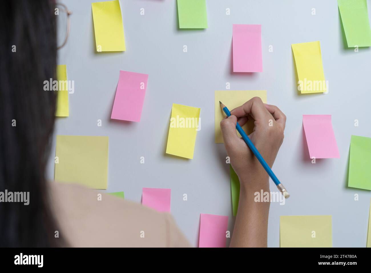 Woman writing notes on sticky paper hi-res stock photography and images ...