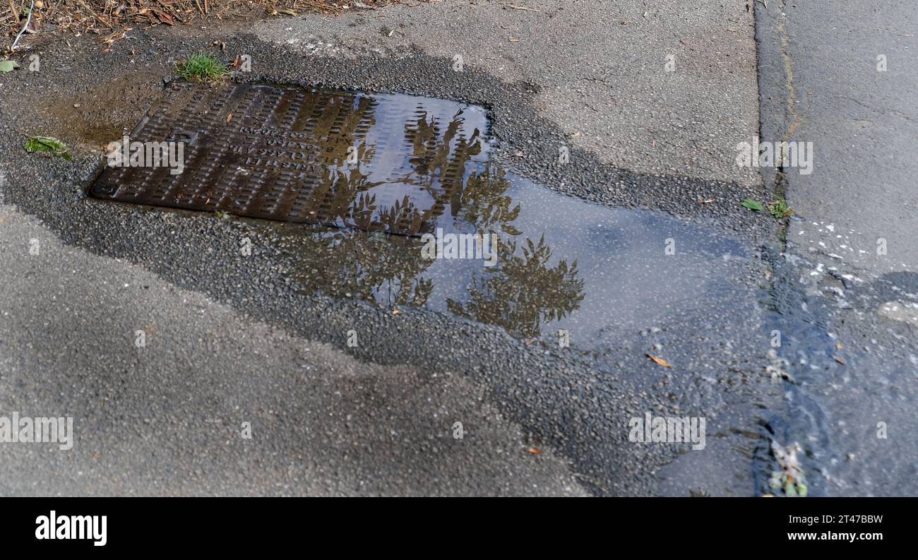Sewer drain overflowing on footpath Stock Photo - Alamy