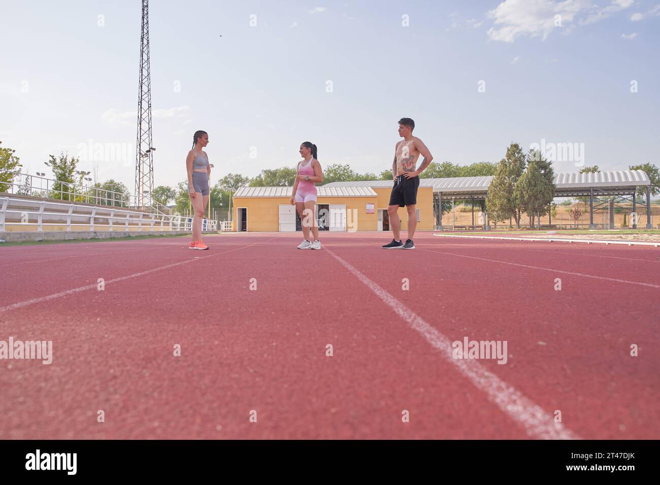 three people standing on the athletic track Stock Photo - Alamy