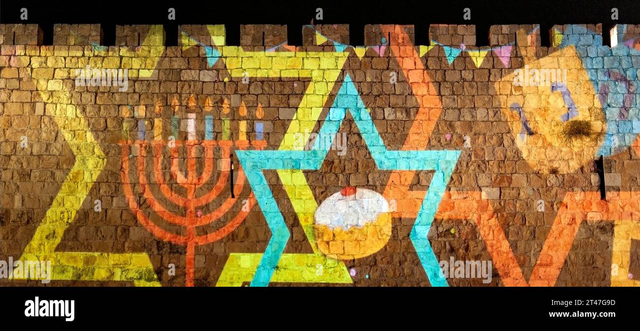 Colorful symbols of the Jewish holiday of Hanukkah are projected on the ...