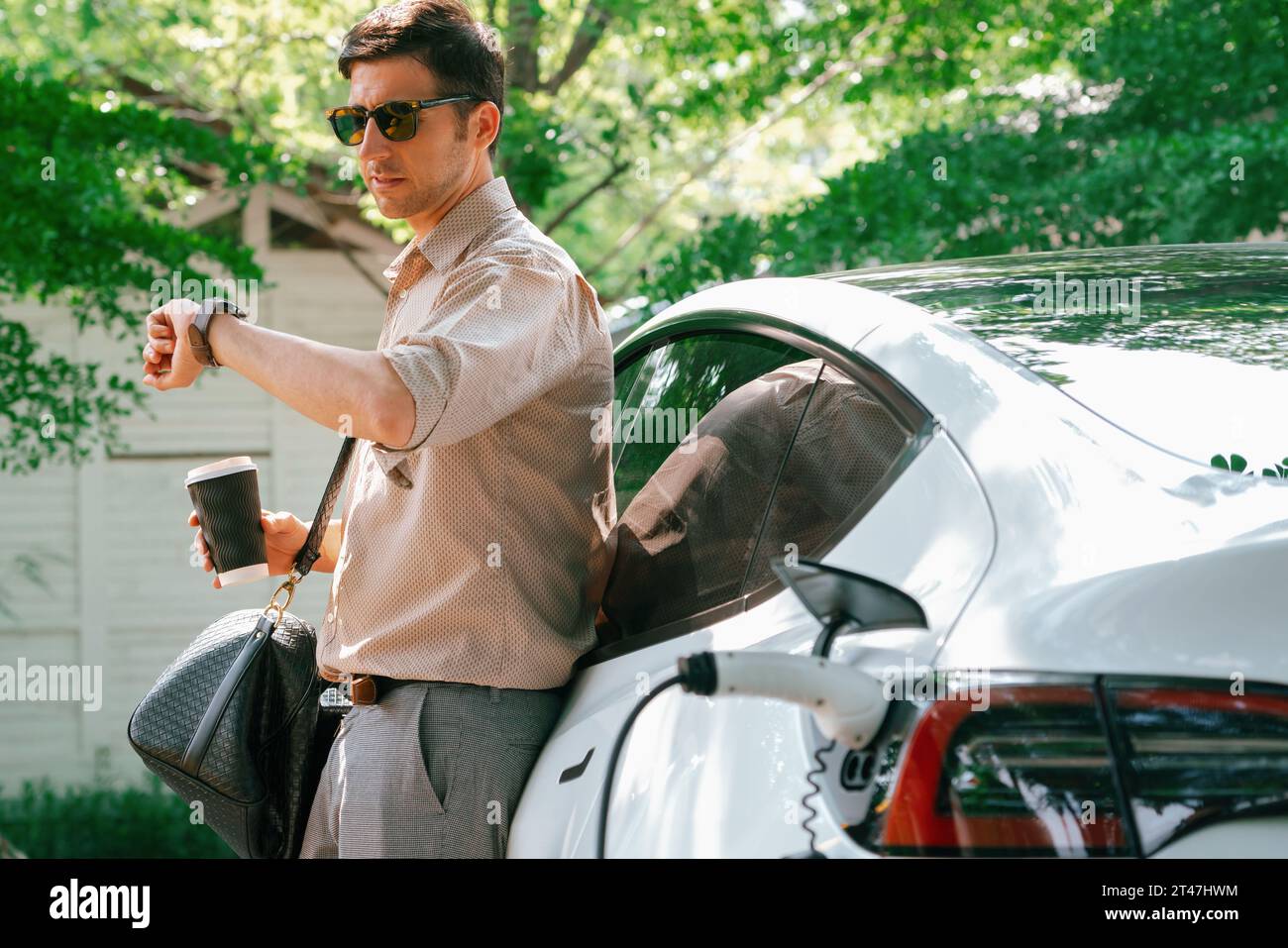 Eco friendly man and sustainable urban commute with EV electric car ...