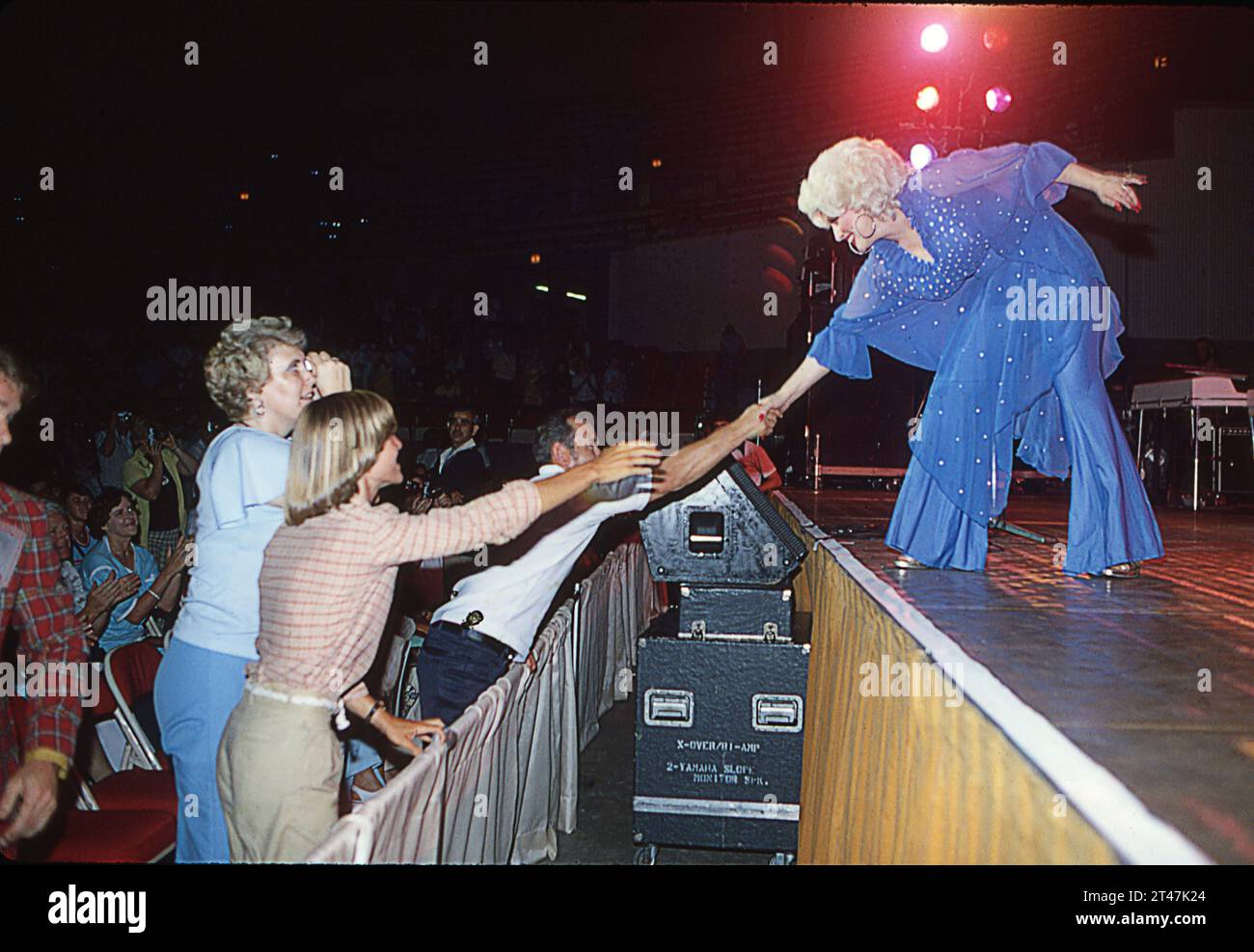 At a live concert, country music superstar Dolly Parton goes to the ...