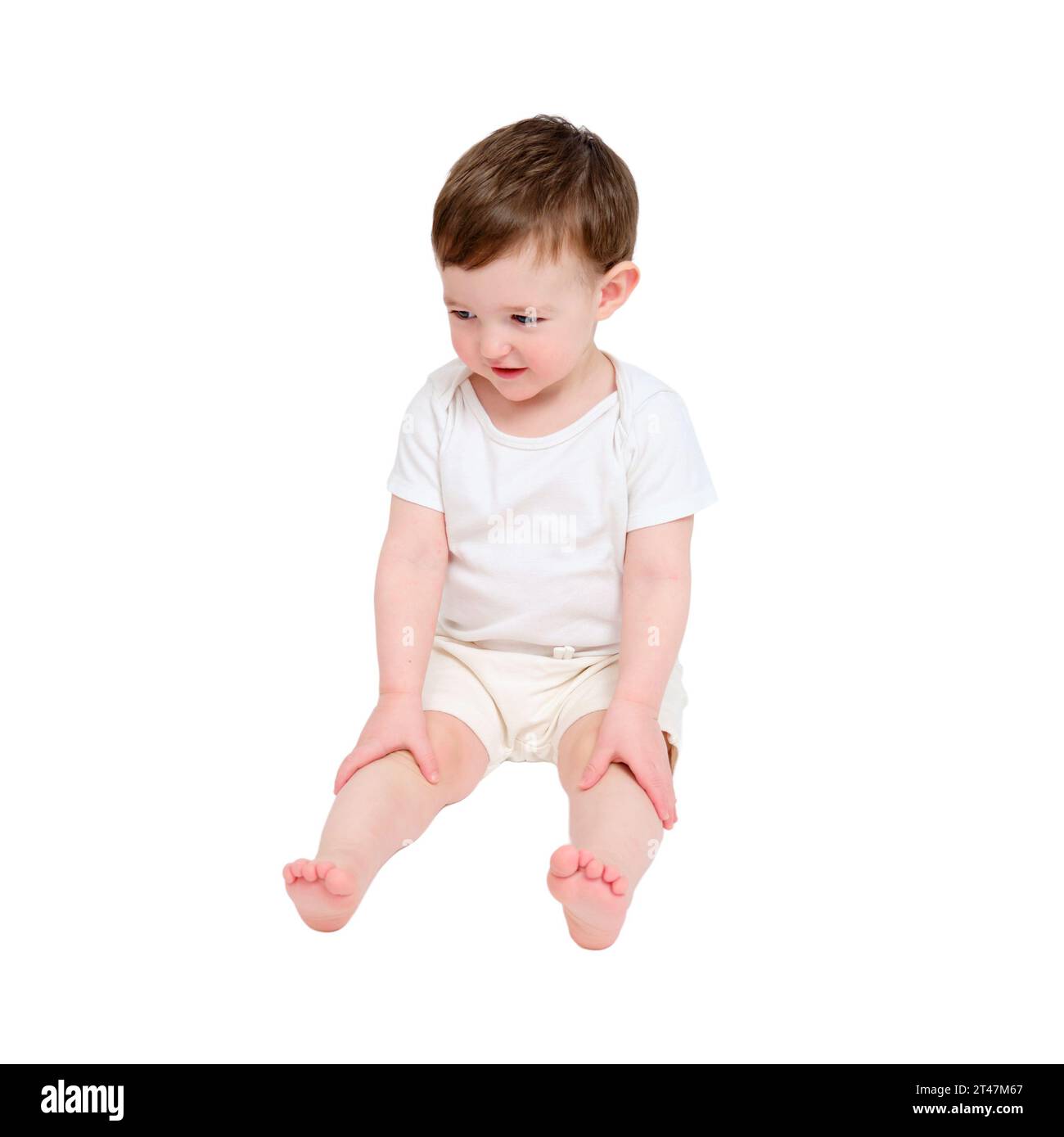 A happy baby is sitting on a studio, isolated on white background. Full ...