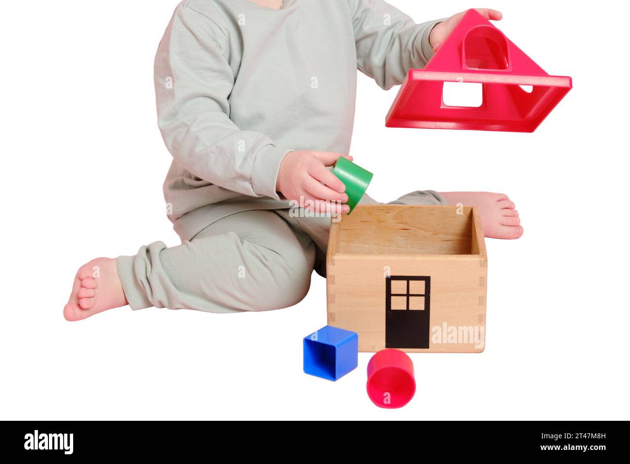 Happy toddler baby plays sorter with geometric shapes on studio ...