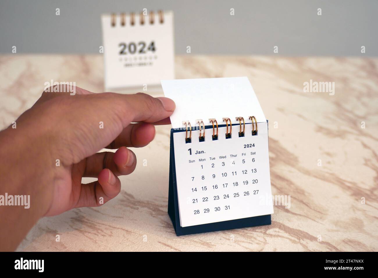 A man's hand turns over a calendar sheet. January of the year change ...