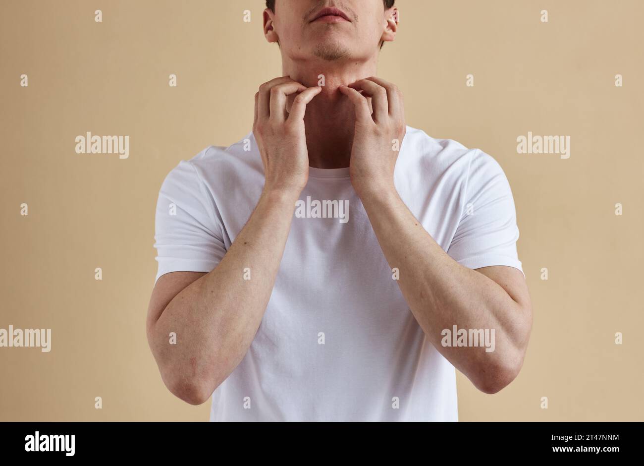Minimal cropped shot of young man scratching neck suffering from itch ...