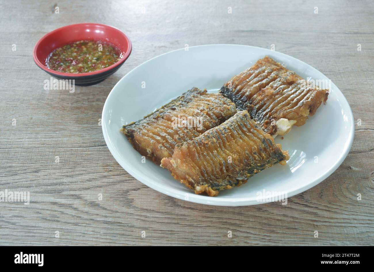 crispy fried chop large head hair tail fish arranging on plate dipping ...