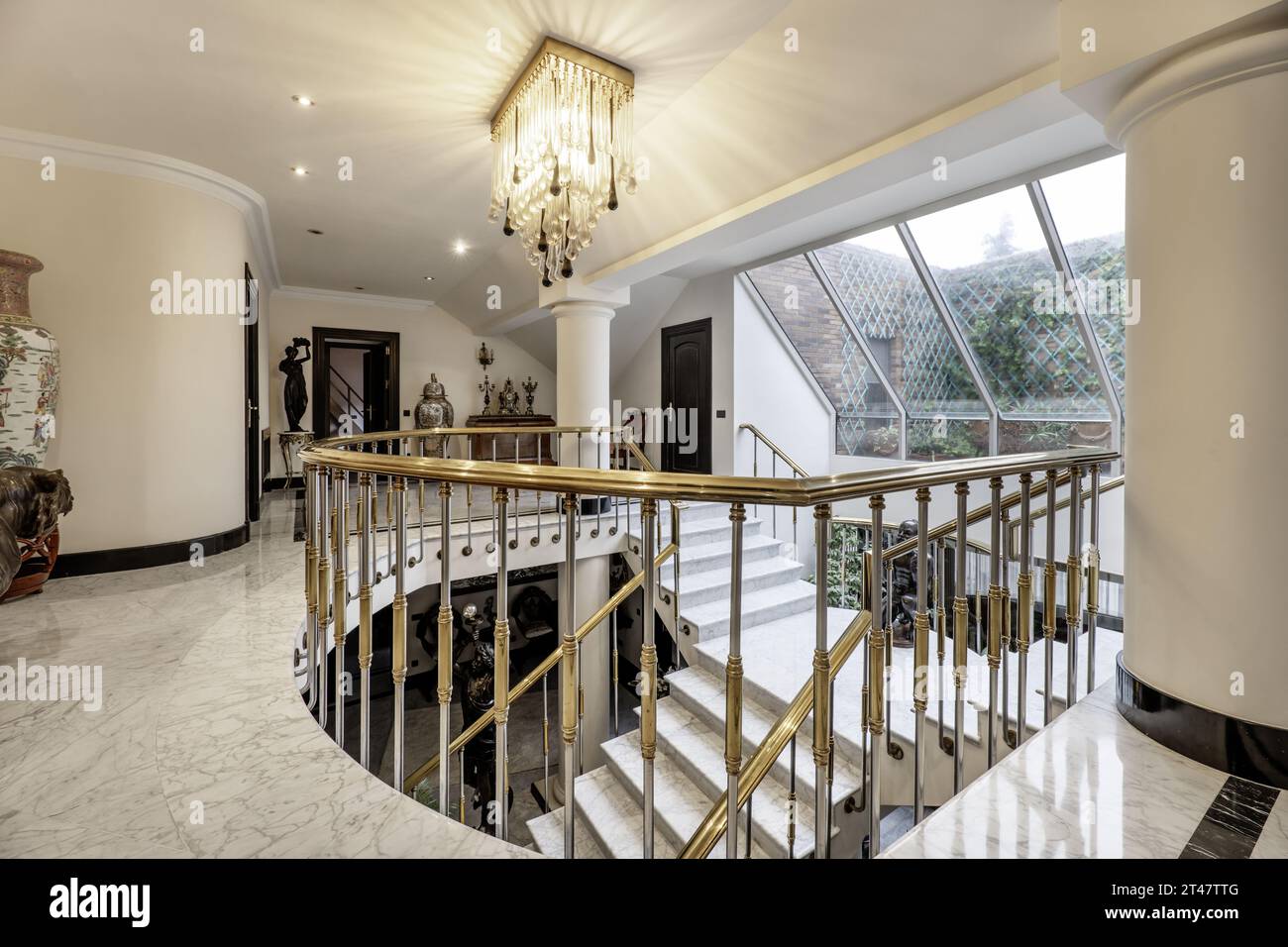 Stairwell of a single-family luxury home with chrome metal railing and ...
