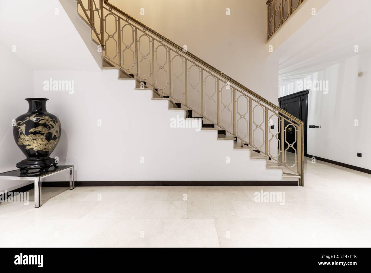 Staircase of a luxury house with chrome metal railing and golden ...