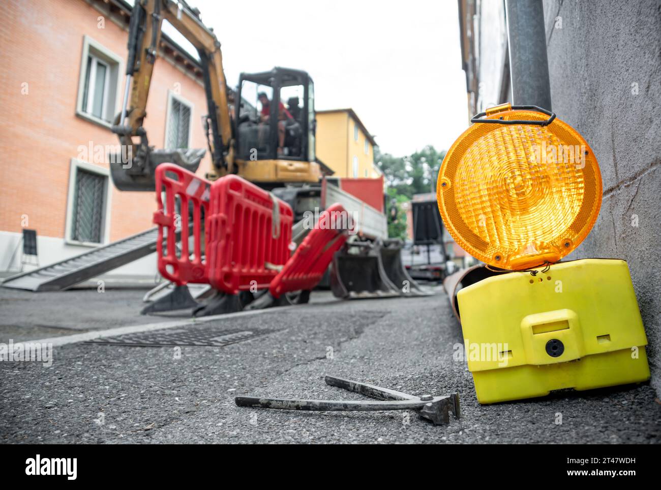 Safety lantern on construction work with red barriers and excavator ...