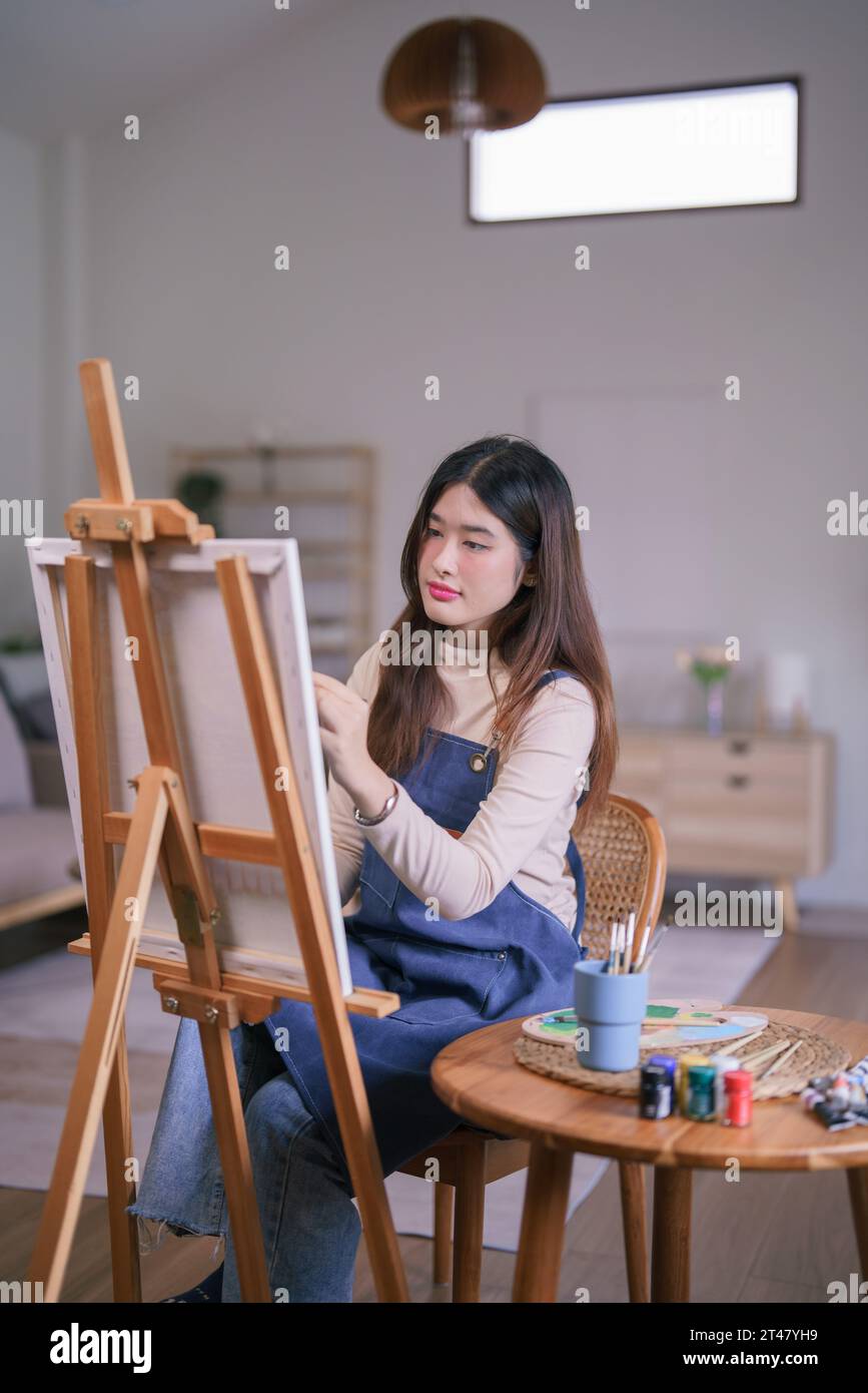 Young asian female artist working to drawing and painting for create ...