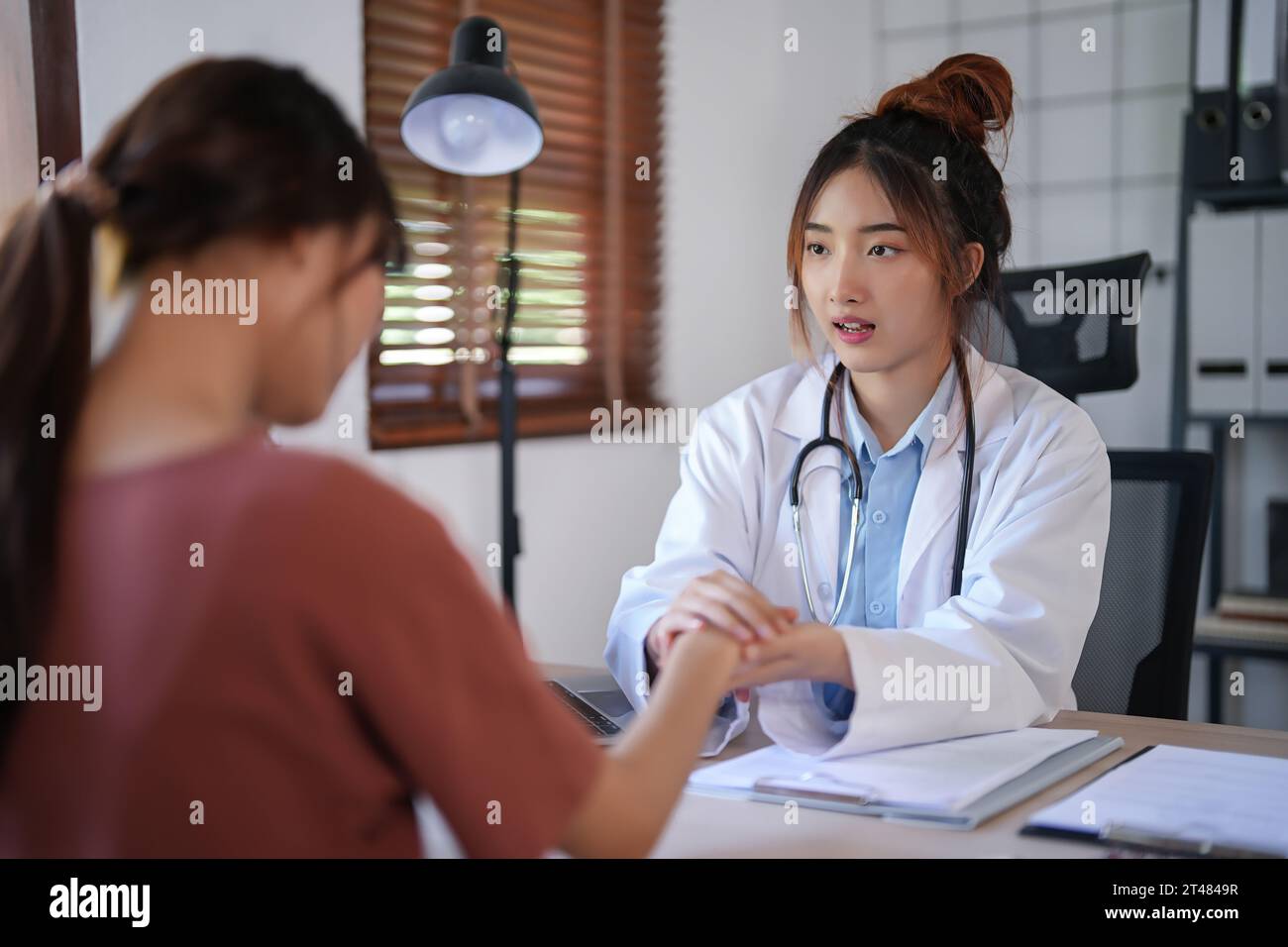 Asian psychologist women holding hand to encouraging patient and giving ...