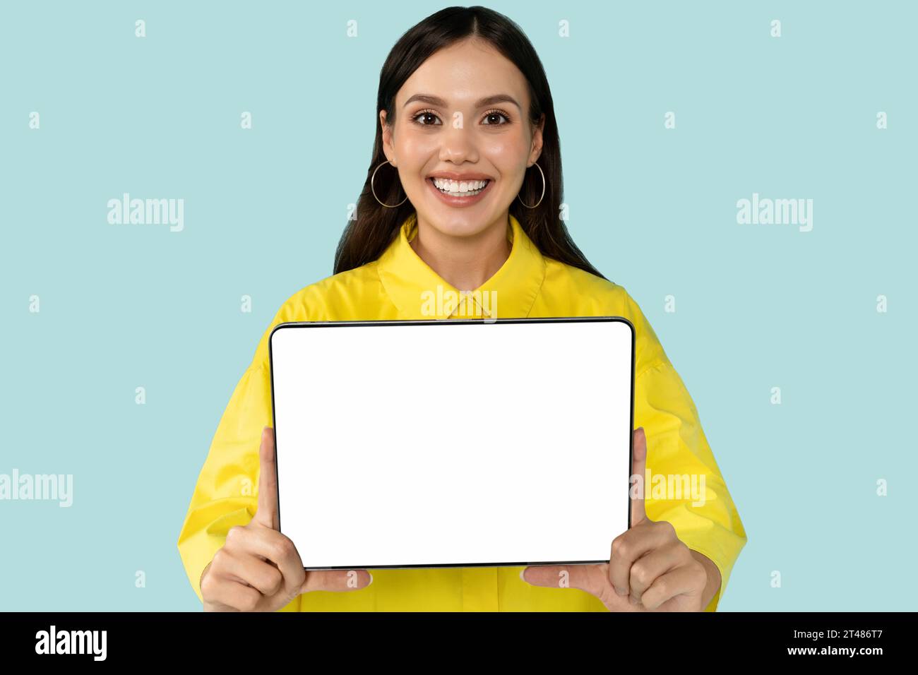 Happy young woman showing digital tablet with white screen Stock Photo ...