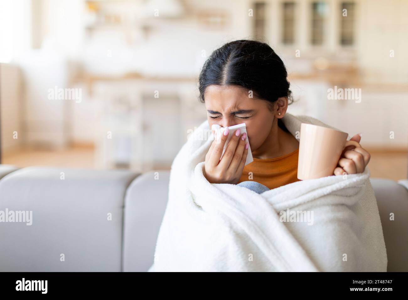 Cold And Flu Symptoms . Sick indian woman covered in blanket blowing ...