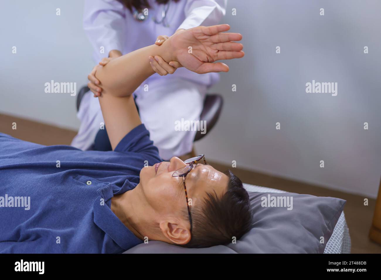 Healthy concept, Senior man lying on bed doing physiotherapy and ...